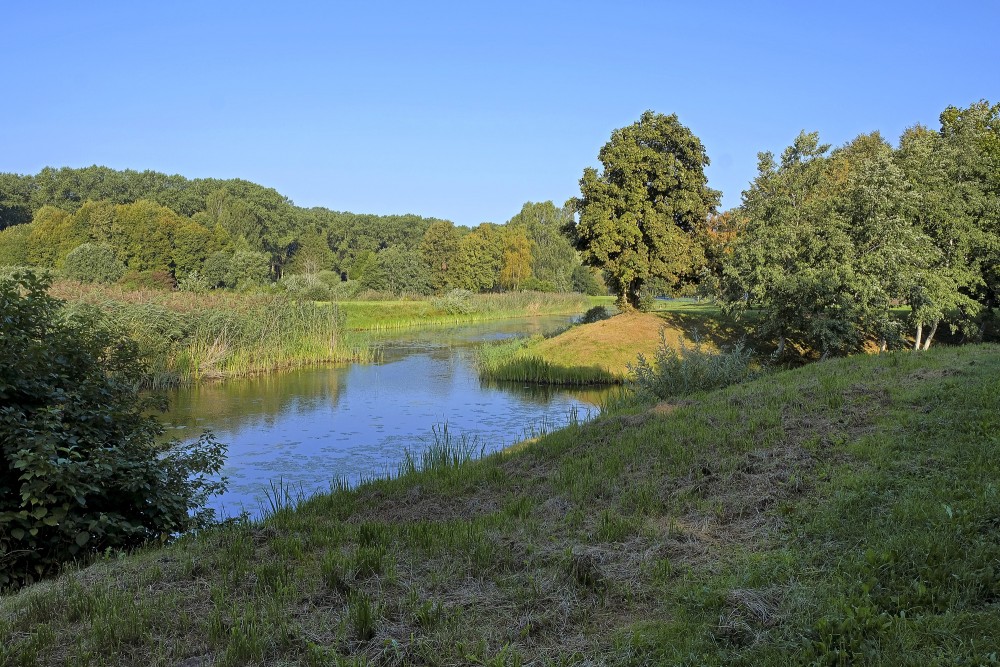 Bend of the Bārta River with tree-lined banks in a Skuodas city park ...