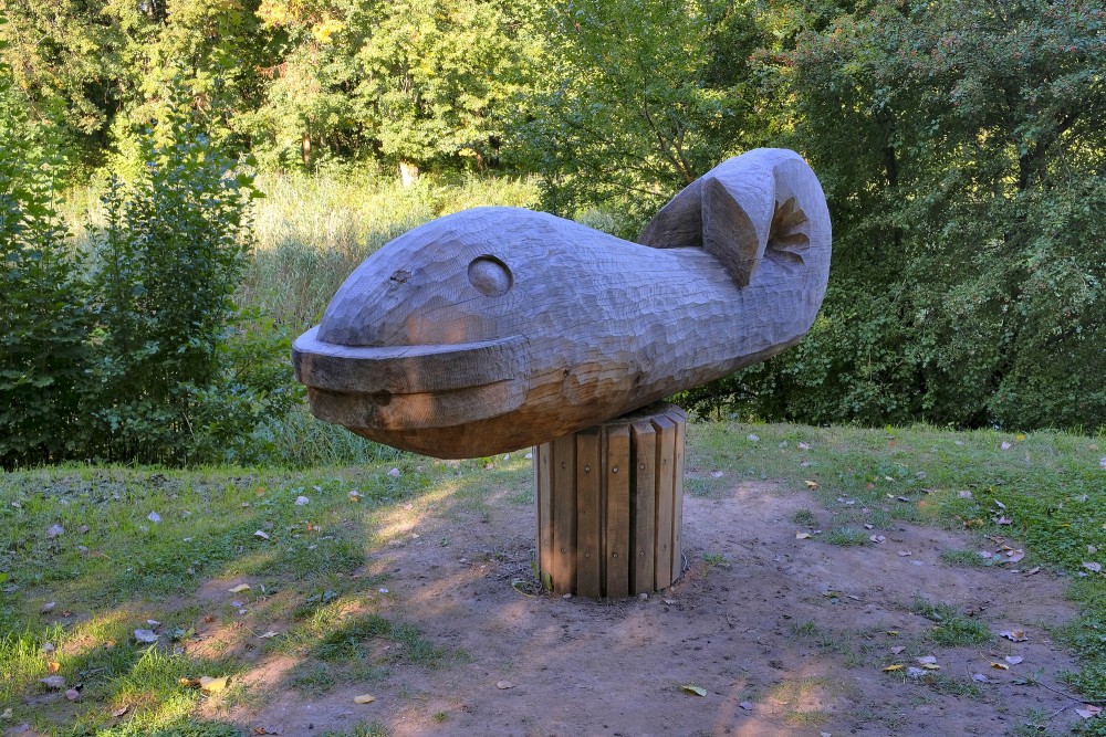 Wooden fish sculpture along a nature trail in a Skuodas city park ...