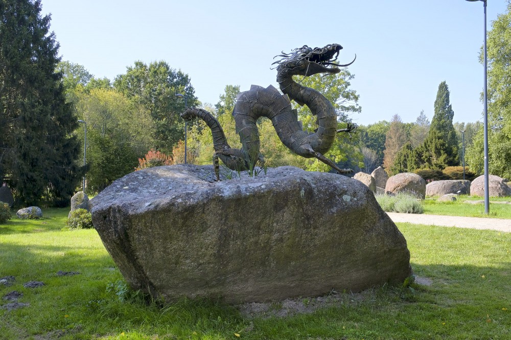 Metal dragon sculpture on a boulder in the stone park - redzet.lv