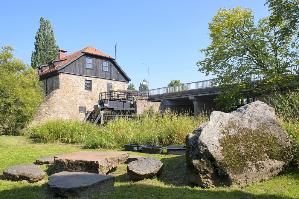Historic stone building (Mosede Watermill) and bridge in a stone park ...