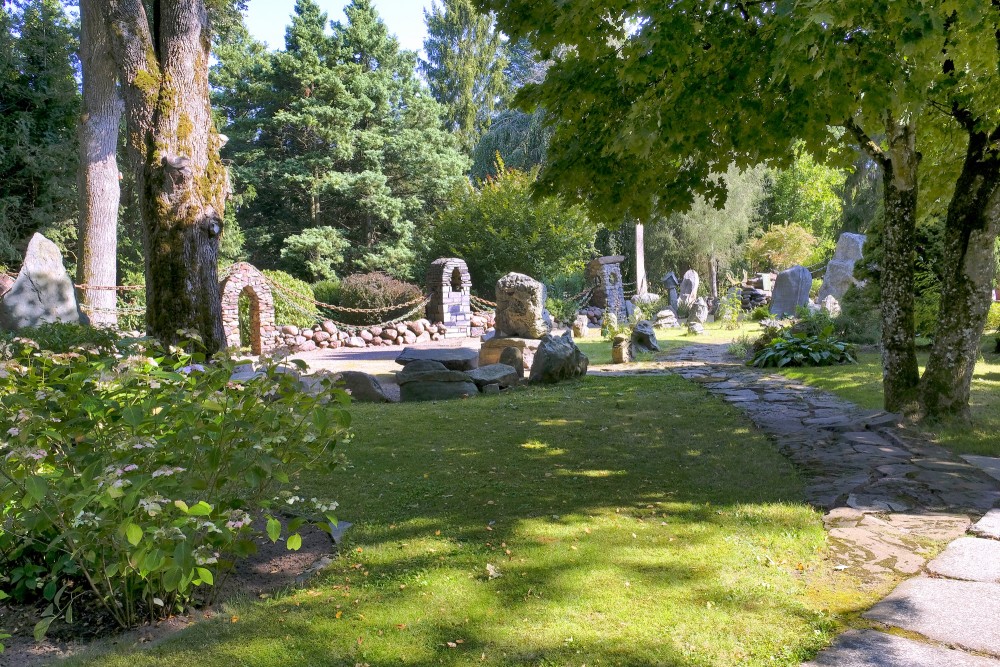 Stone pathway in a garden with sculpture and decorative boulders ...